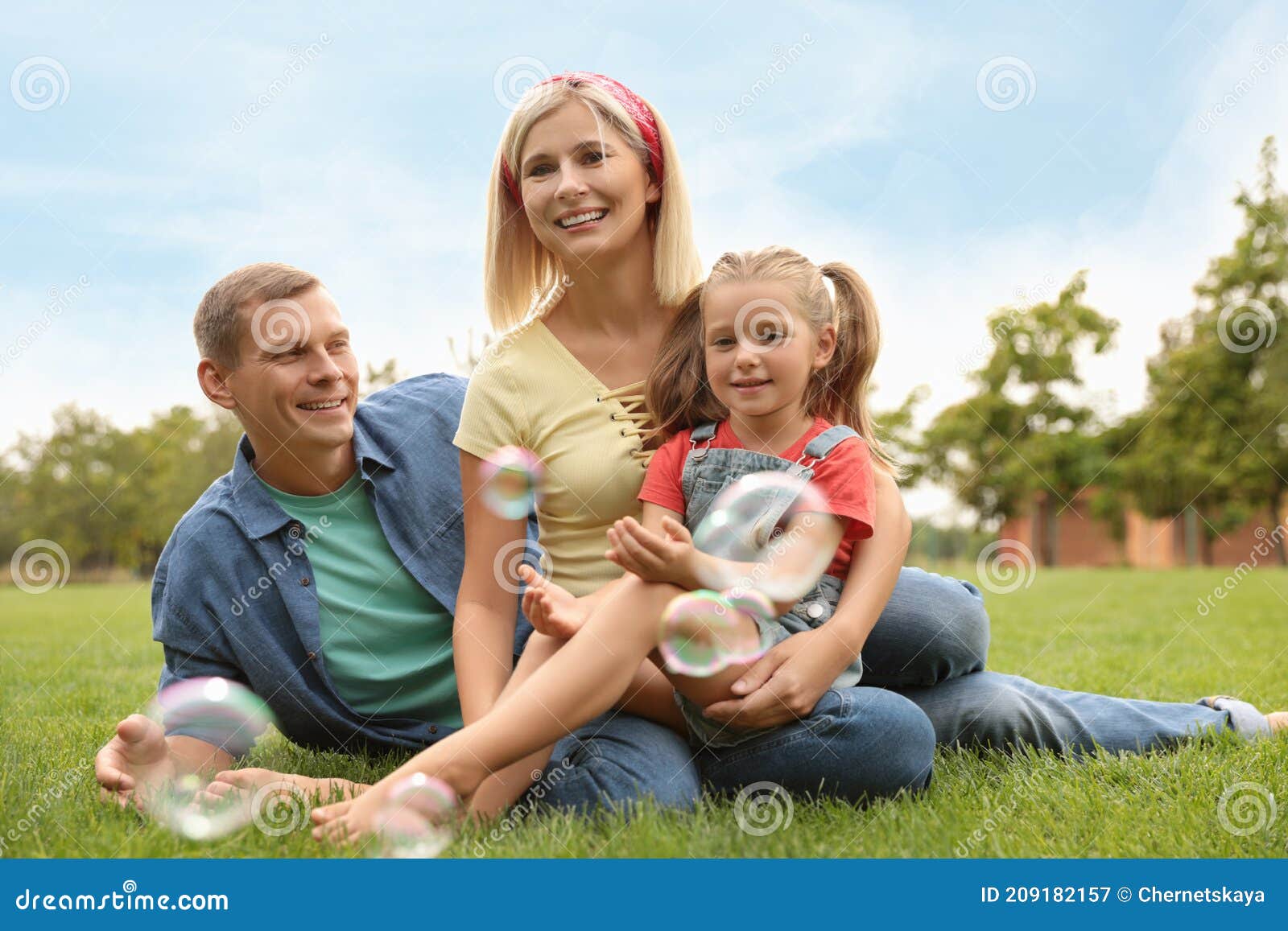 Happy Family Blowing Soap Bubbles in Park on Green Grass Stock Image ... Happy Family Blowing Soap Bubbles in Park on Green Grass Stock Image ...