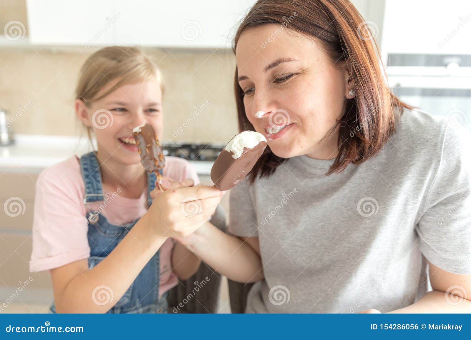 Mother With Daughter In Kitchen Eating Ice Cream Good Relations Of