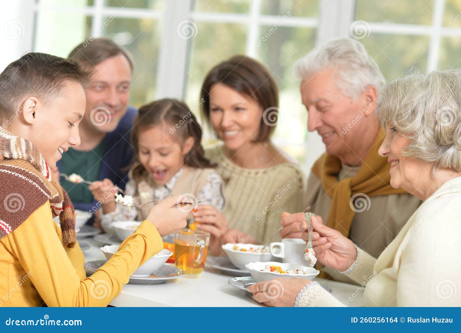 Happy Family of Different Generations Eating Together Stock Photo ...