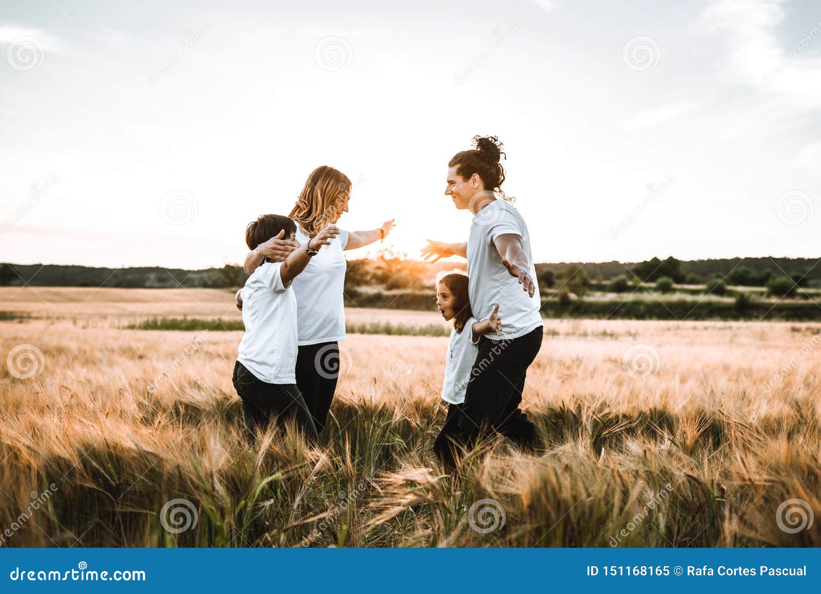 Happy Family Hugging in the Field and Smiling. Family in a Sunset Stock ...