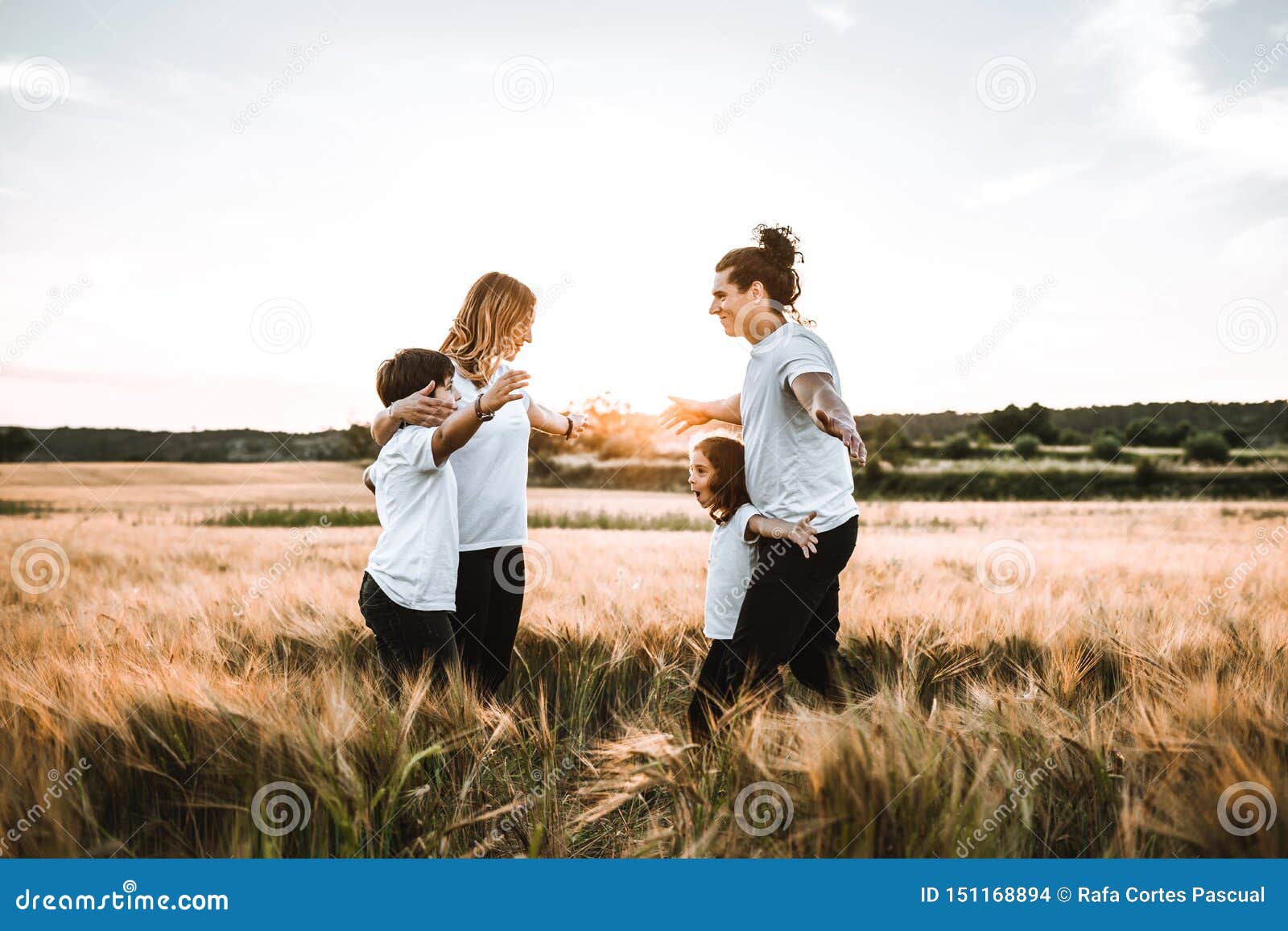Happy Family Hugging in the Field and Smiling. Family in a Sunset Stock ...