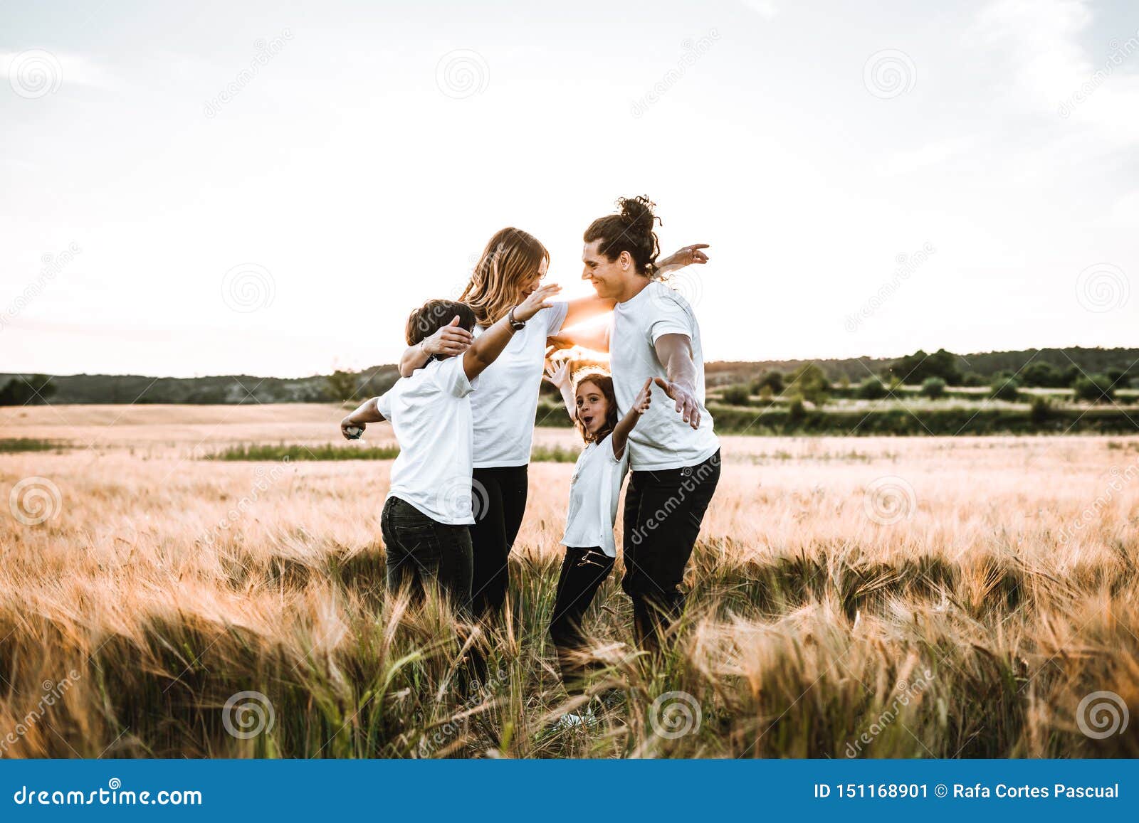Happy Family Hugging in the Field and Smiling. Family in a Sunset Stock ...