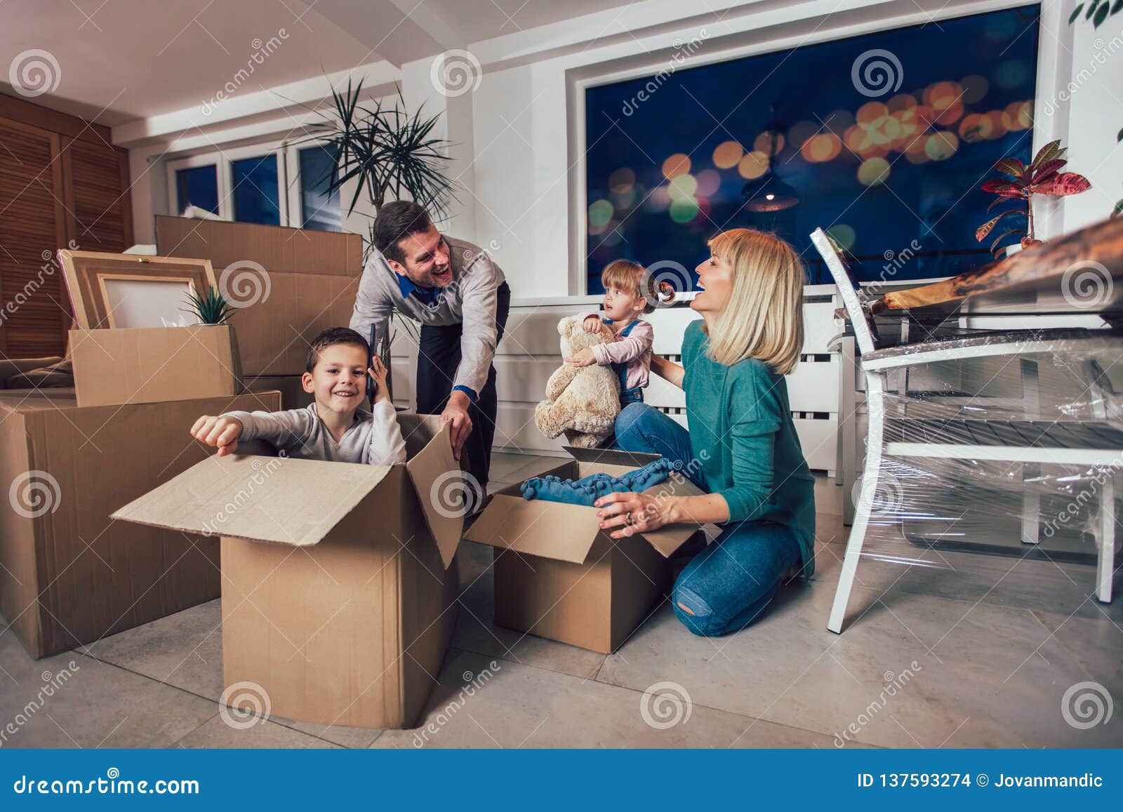 Family Moving Home with Boxes Around Stock Photo - Image of house ...