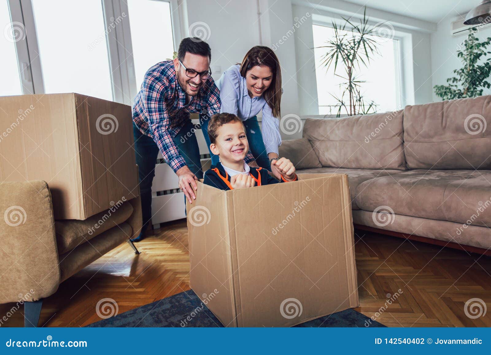 Family Moving Home with Boxes Around, and Having Fun Stock Photo ...