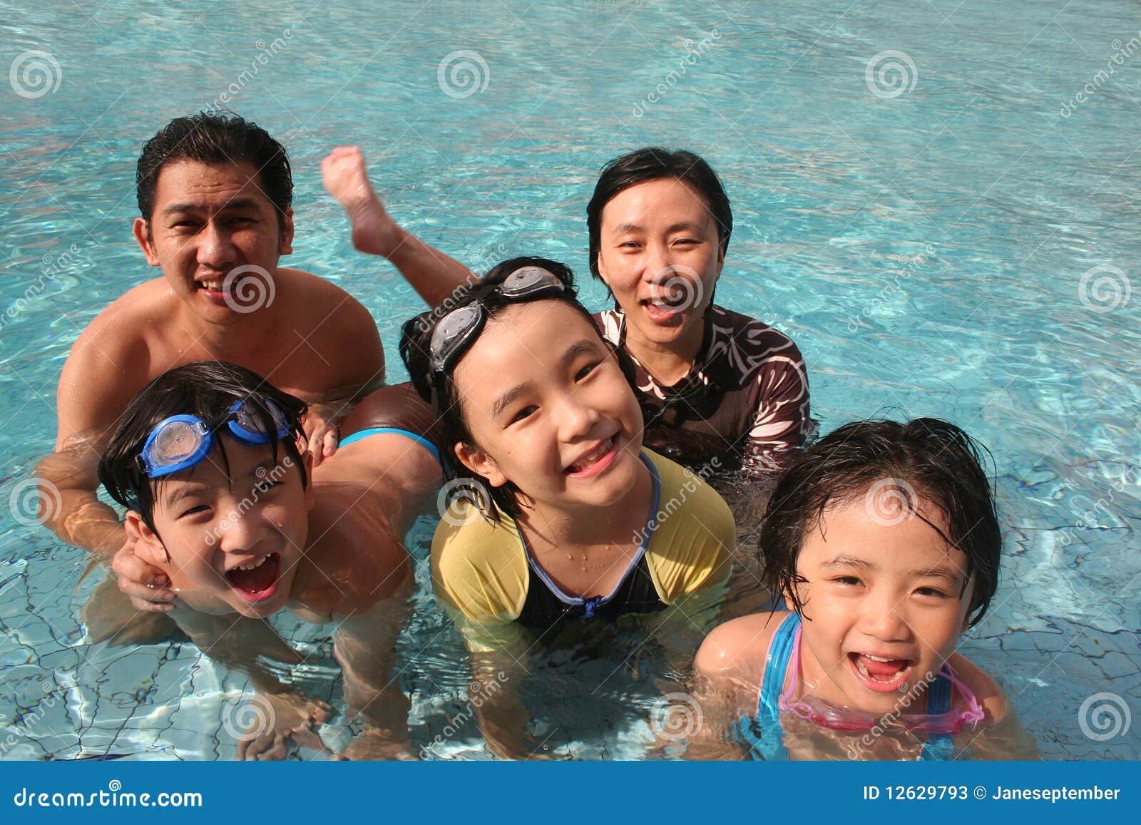 Happy family in the pool stock image. Image of excitement - 12629793