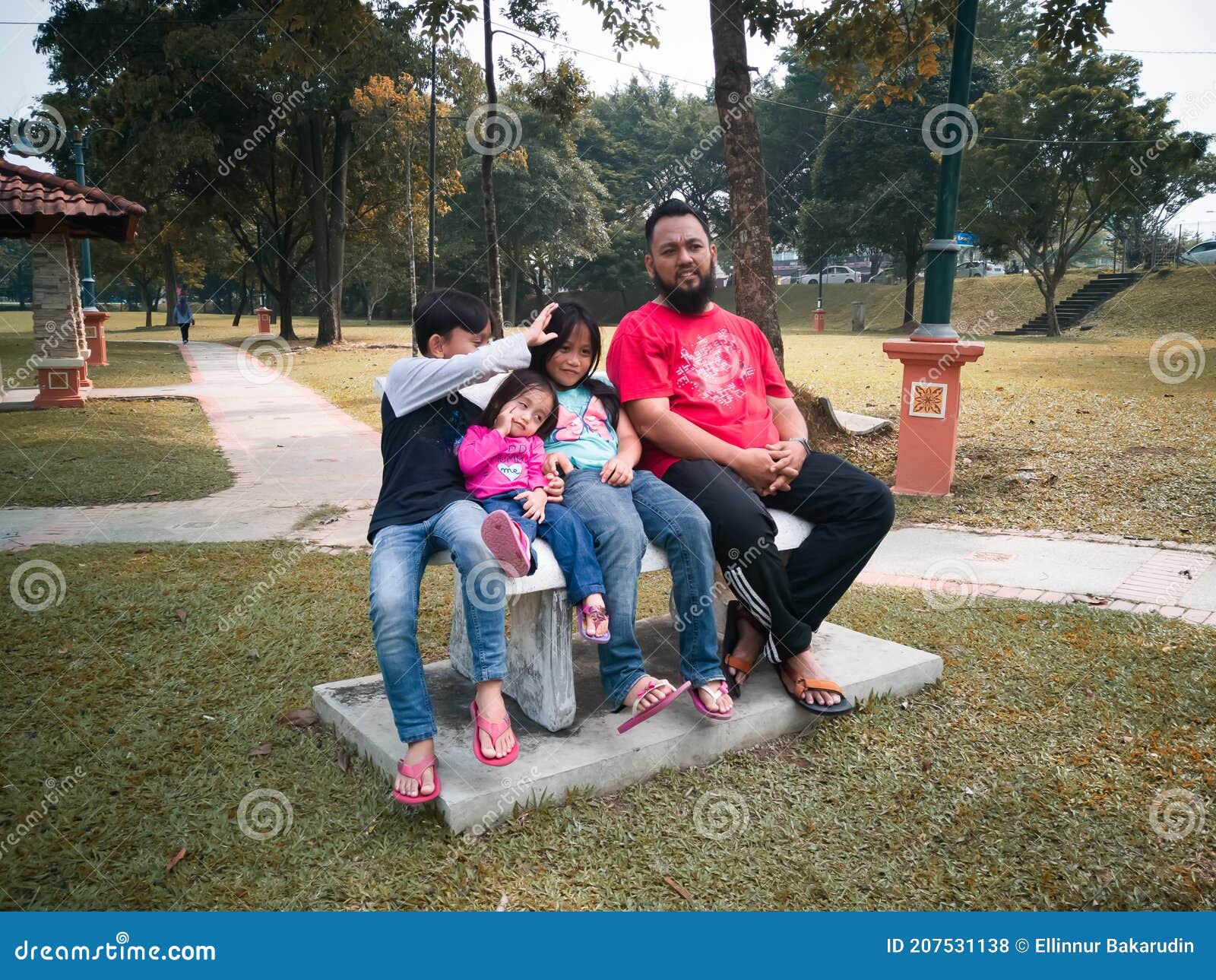 A Happy Family is Sitting on the Bench in the Park Stock Photo - Image ...