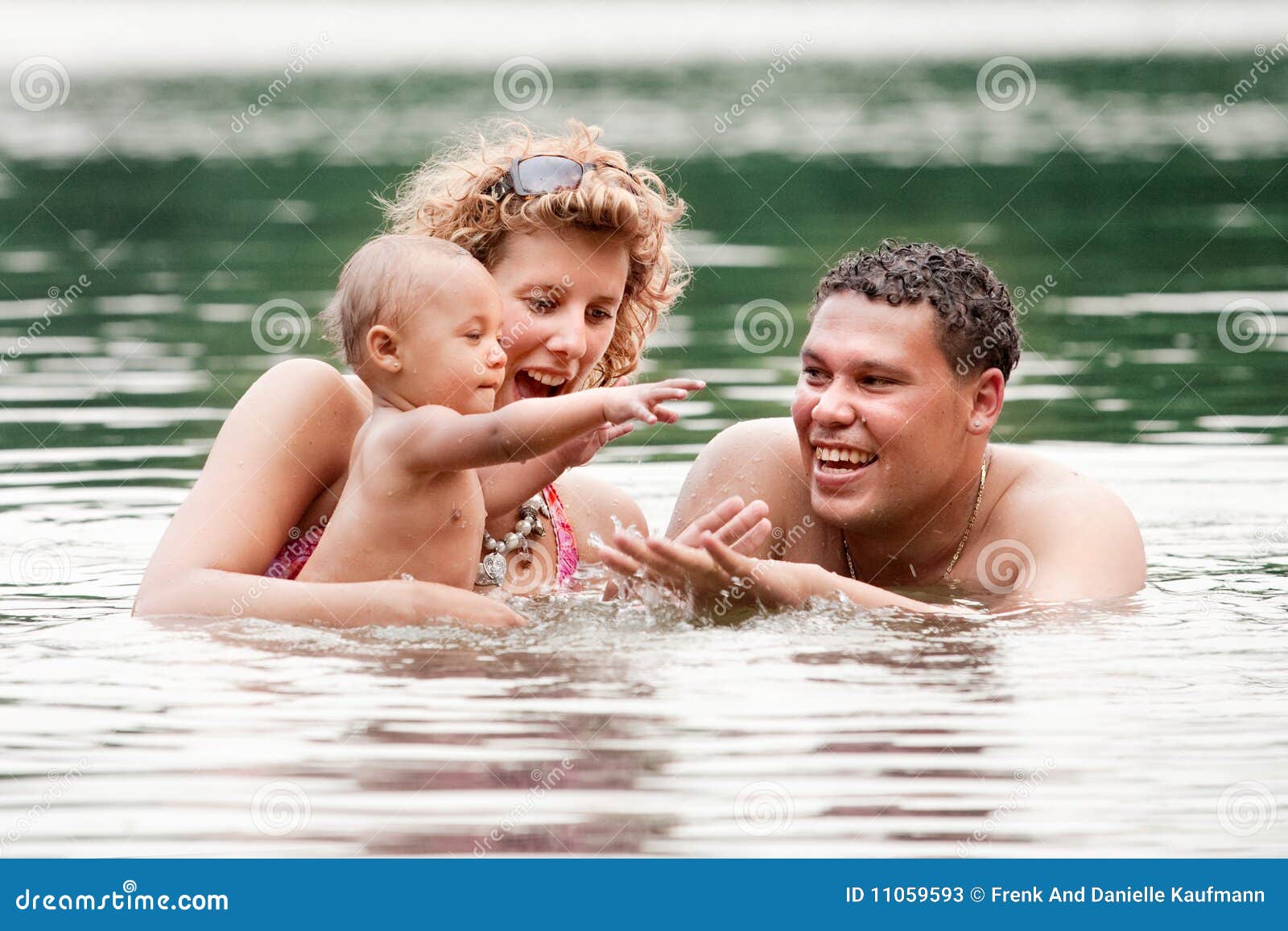 Happy family in the water stock image. Image of cuddling - 11059593