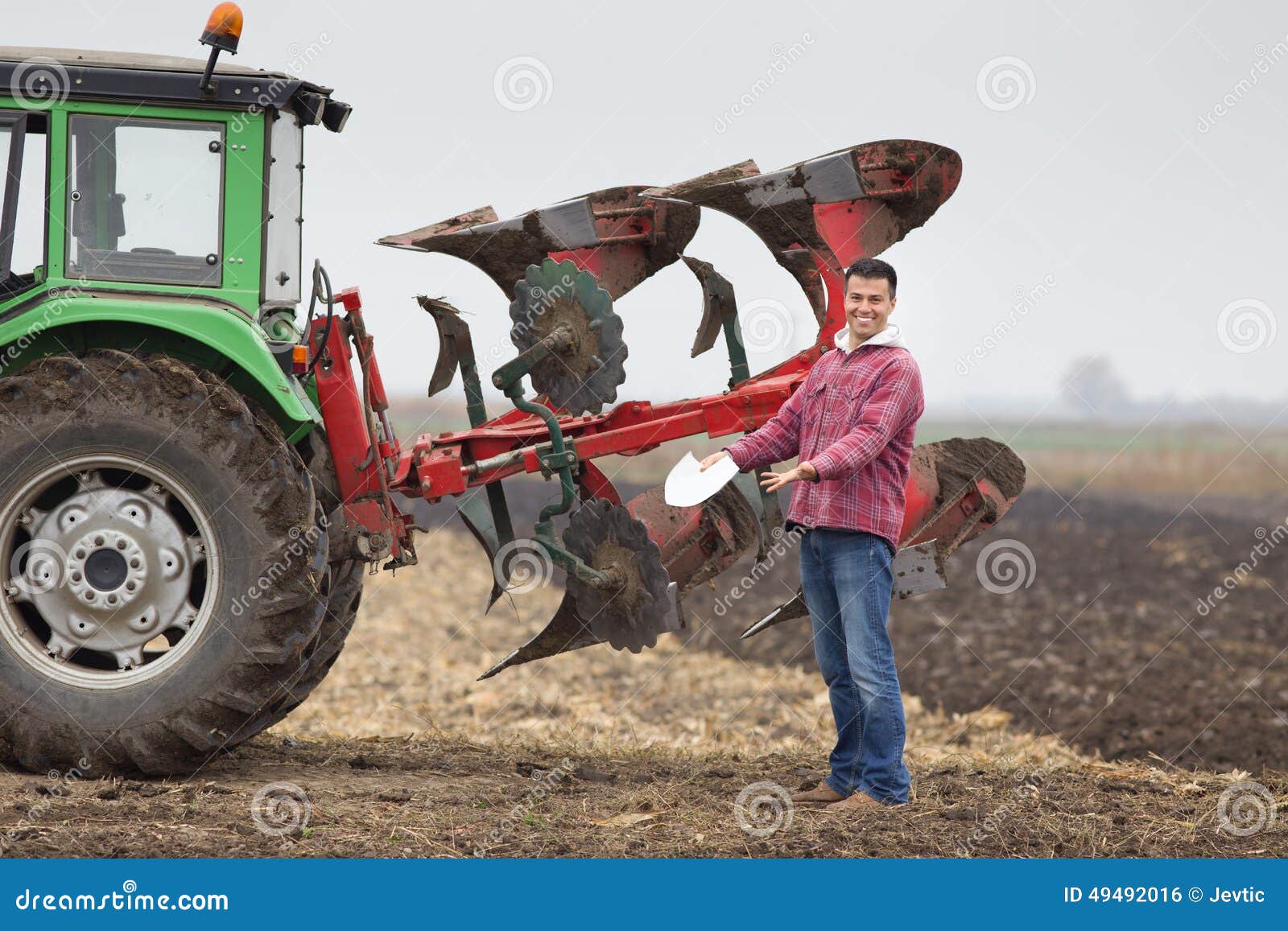 Happy farmer beside plough stock photo. Image of green - 49492016