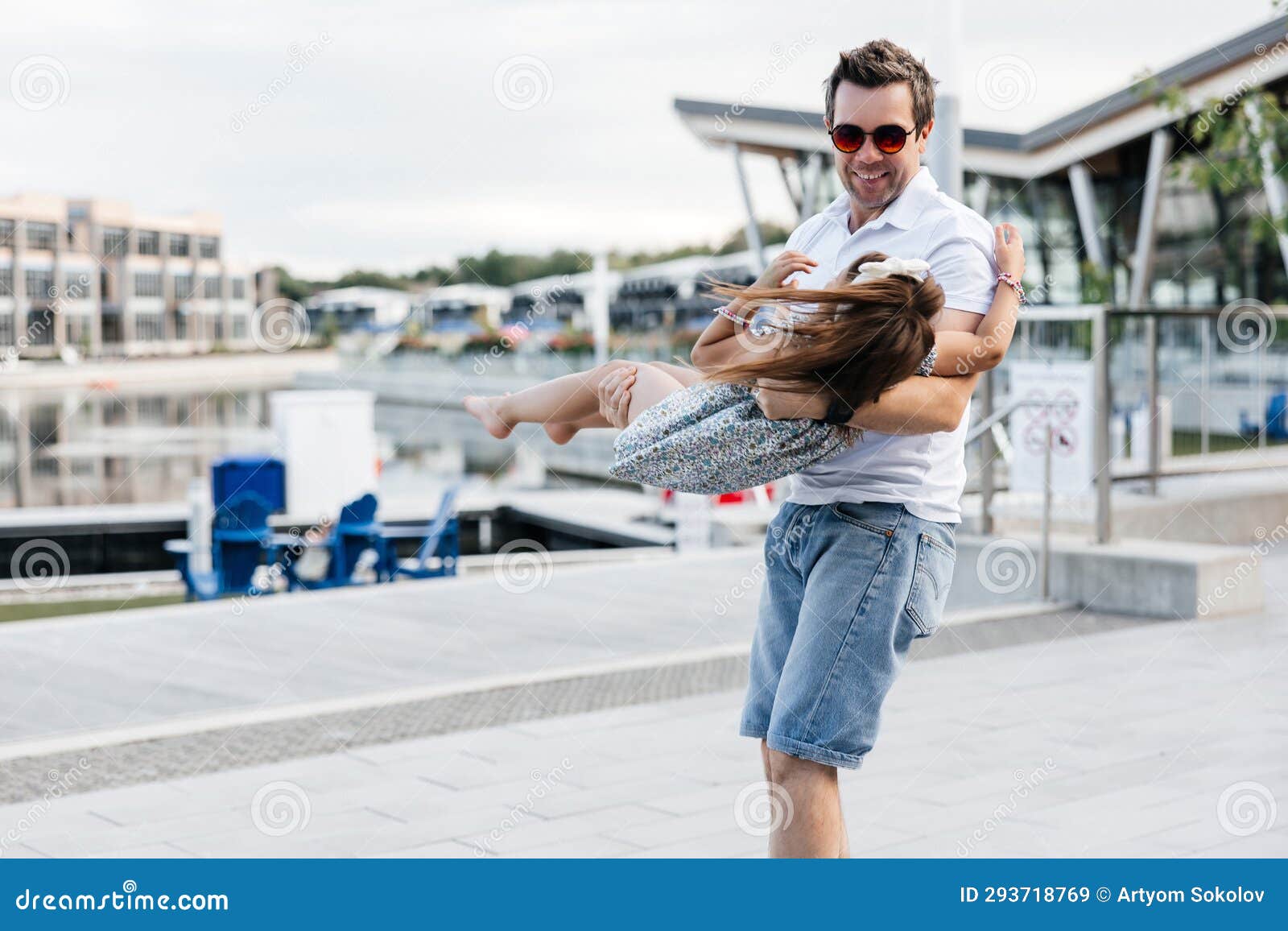 A Happy Father Holds His Daughter in His Arms and Spins Her Around ... A Happy Father Holds His Daughter in His Arms and Spins Her Around ...