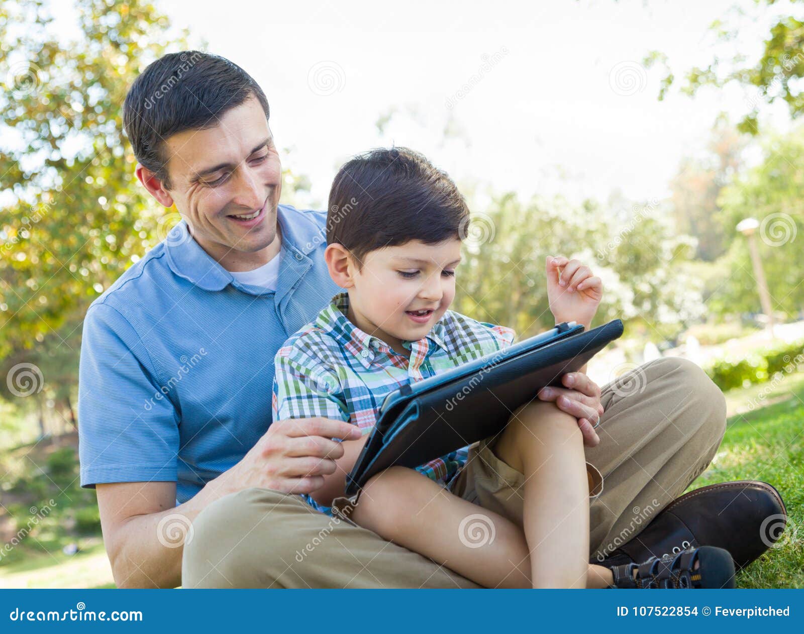 Helpful Father and Son Playing on a Computer Tablet Outside. Stock ...