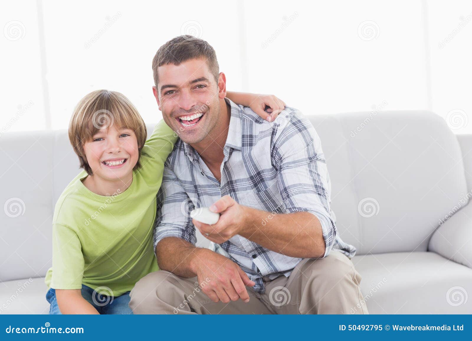 Happy Father and Son Using Remote Control on Sofa Stock Image - Image ...