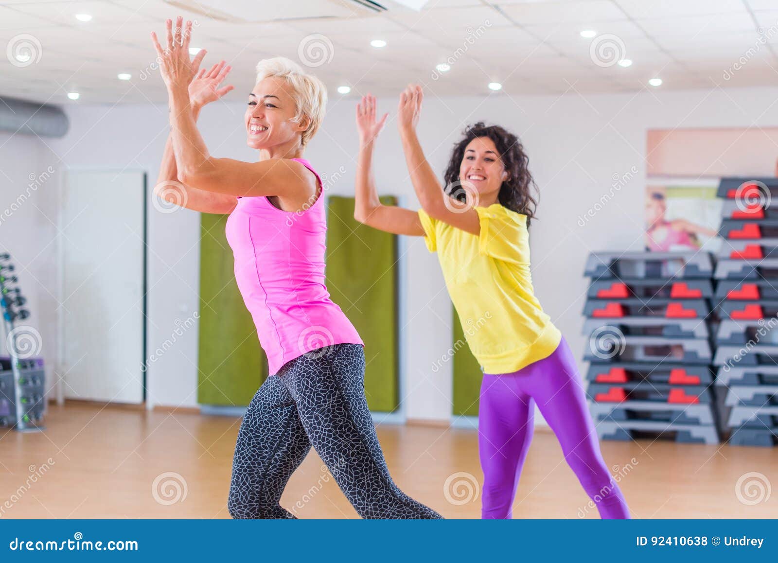 Happy Female Athletes Doing Aerobics Exercises Or Zumba Dance Workout