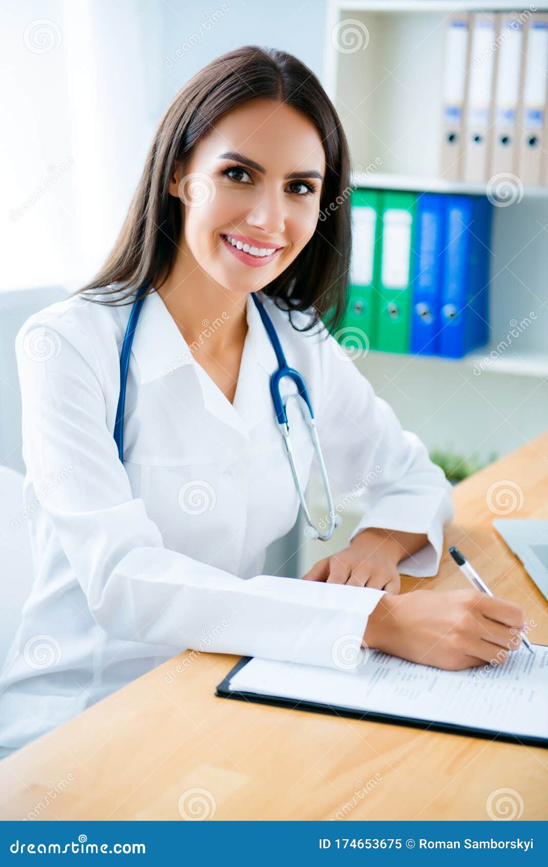 Happy Female Doctor Writing Conclusion For Her Patient Stock Image