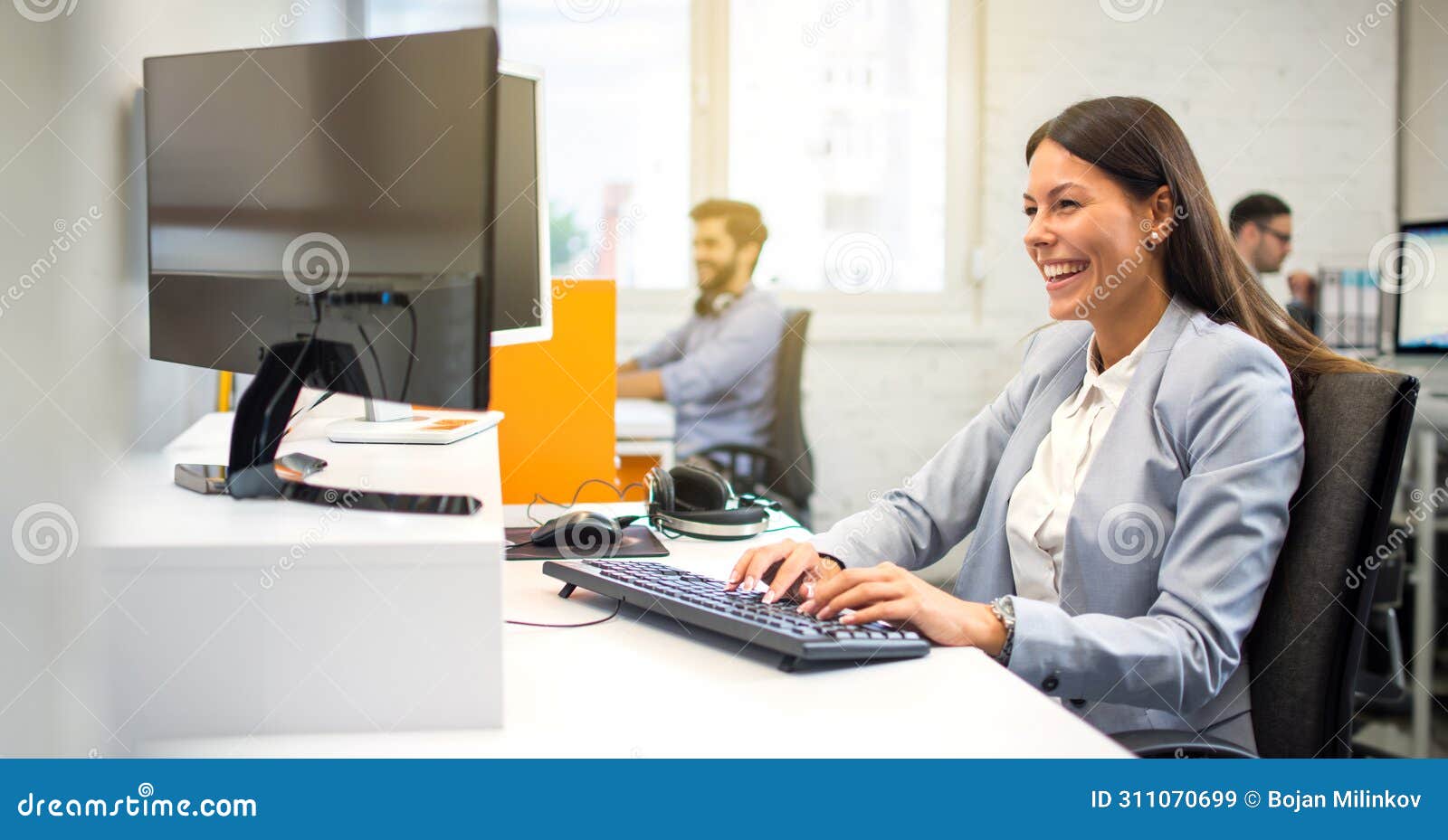 Happy Female Employee in Suit Using Computer at Office. Stock Image ...