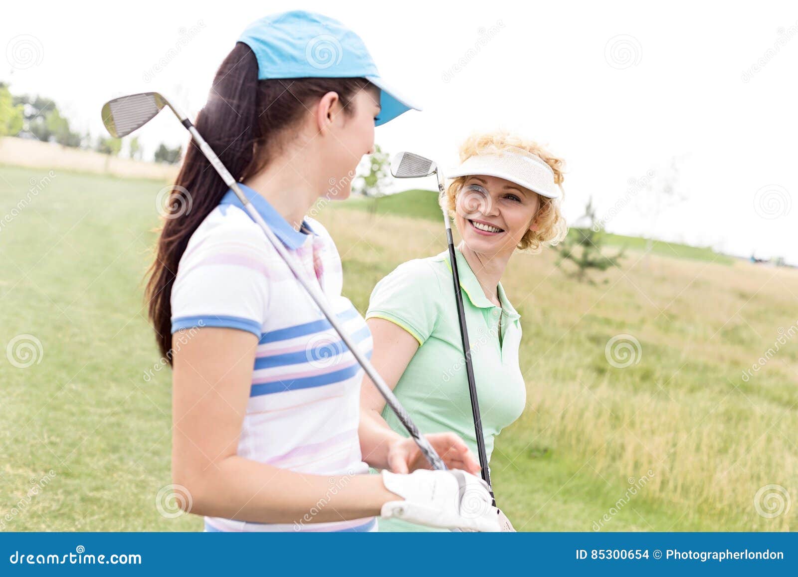 Two Female Golfers Walking Along Fairway Carrying Clubs Royalty-Free ...