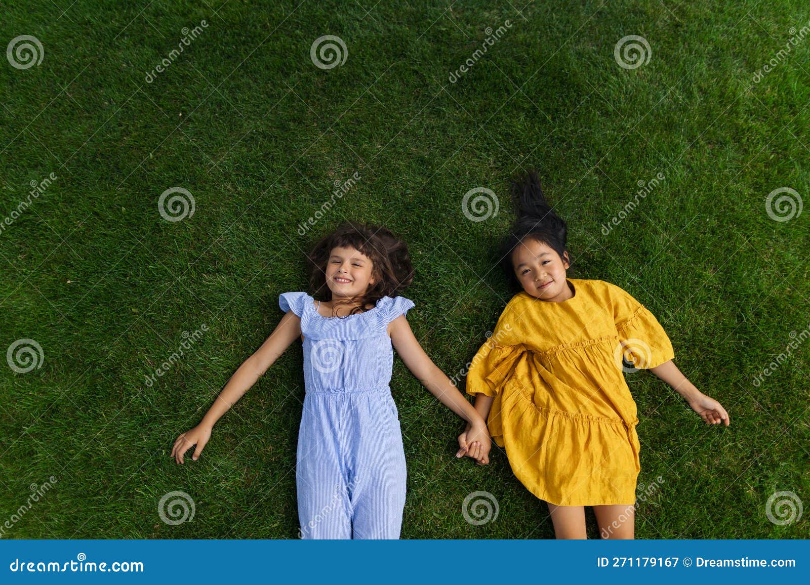 Happy Friends Lying in the Grass, Holding Each Other Hands and Having ...