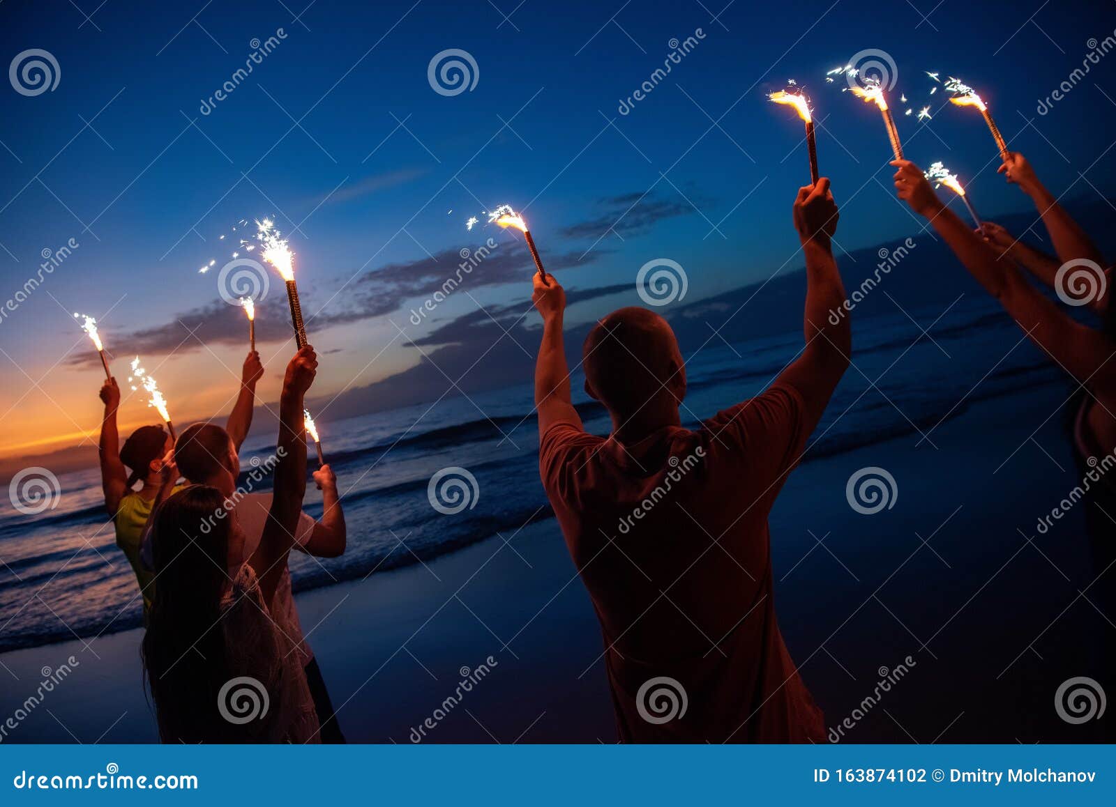 Happy Friends at Sunset Beach Party with Fireworks Stock Photo - Image ...