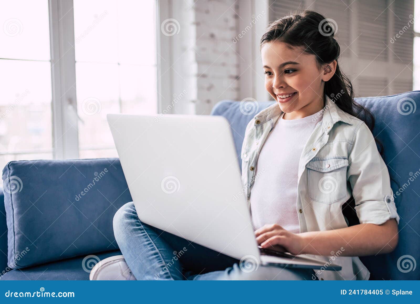 The Happy Girl Sitting on the Sofa with a Laptop. Stock Image - Image ...