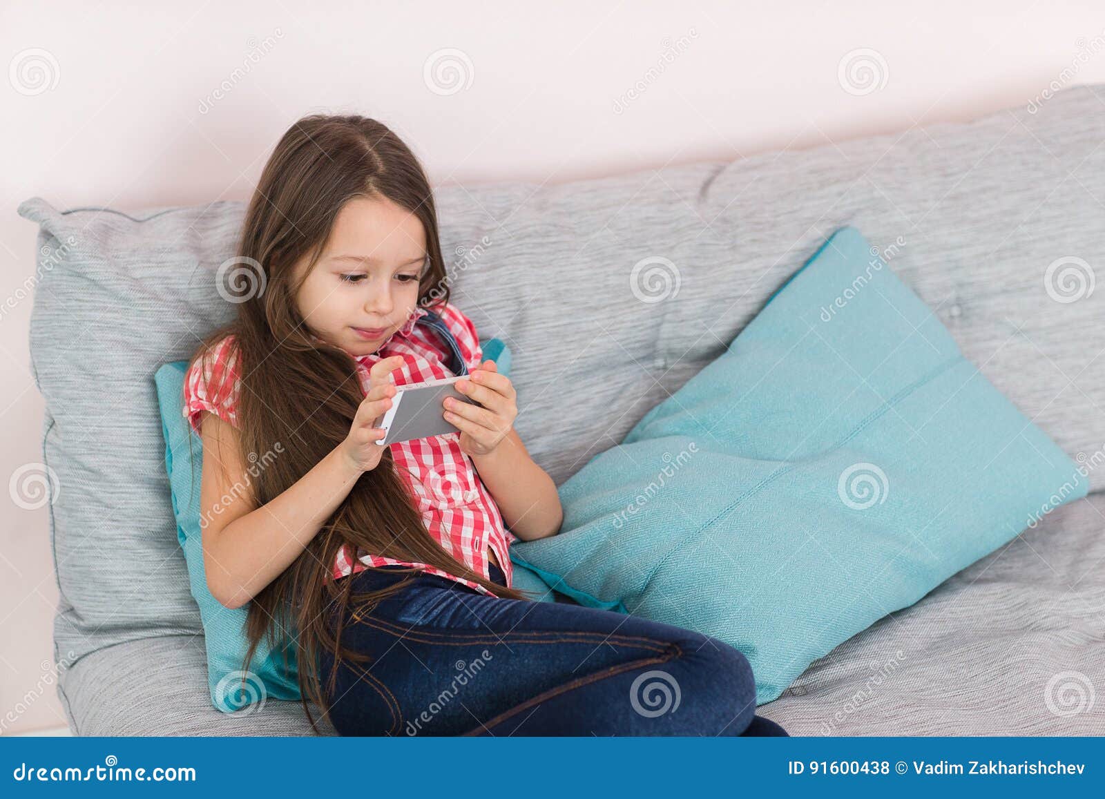 Happy Girl Using Mobile Phone while Sitting on Sofa at Home Stock Photo ...