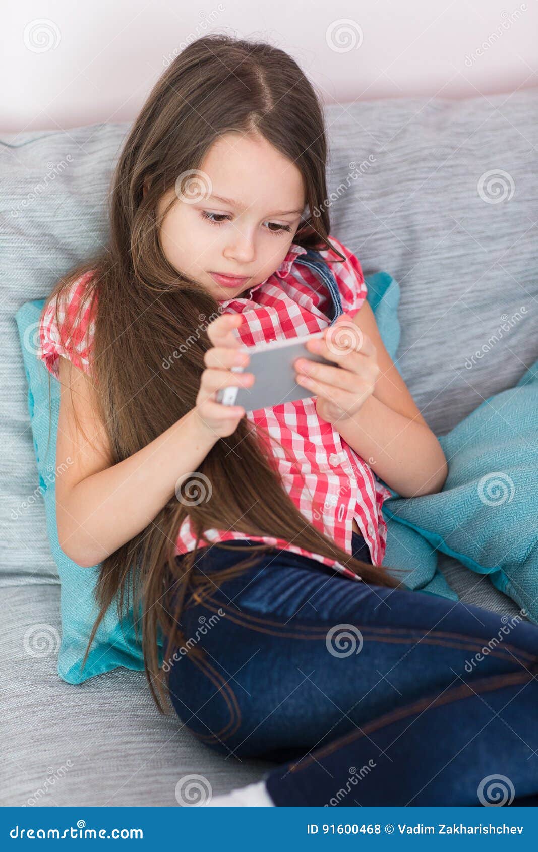 Happy Girl Using Mobile Phone while Sitting on Sofa at Home Stock Photo ...