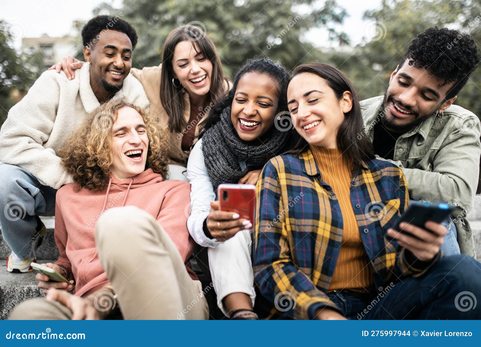 Happy Group Of Young People Having Fun Using Smartphone Outdoors Stock