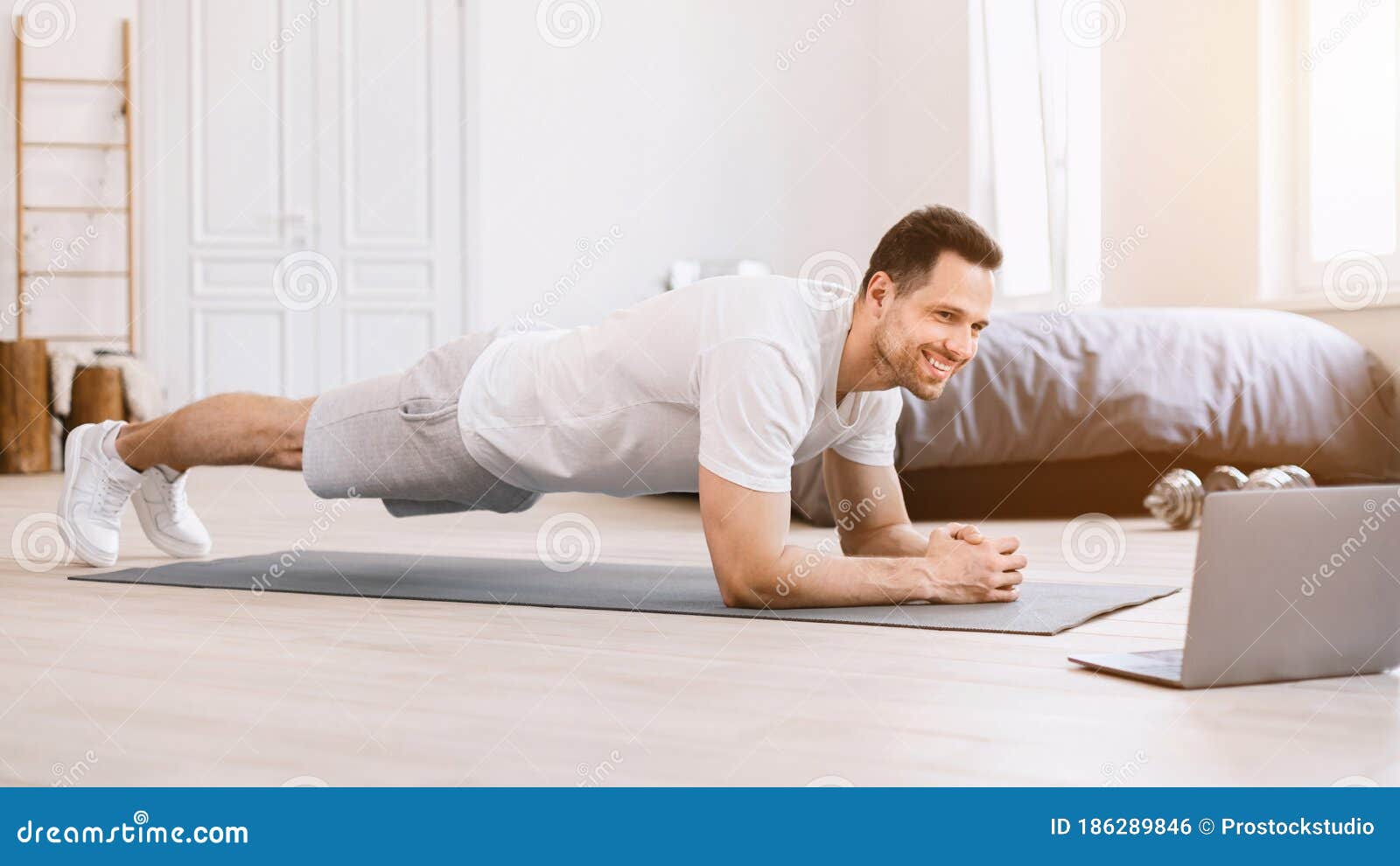 Happy Guy Doing Plank Exercise at Laptop at Home, Panorama Stock Photo ...