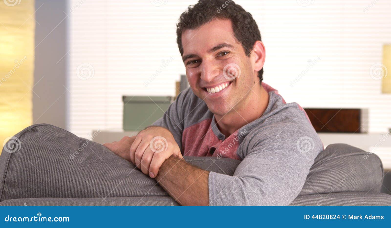 Happy guy sitting on couch stock photo. Image of listening - 44820824