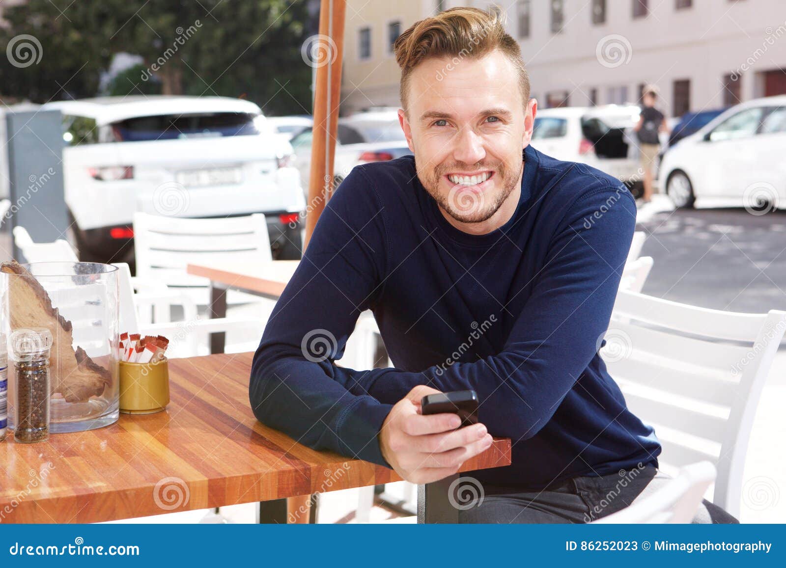 Happy Guy Sitting Outside at Cafe with Mobile Phone Stock Image - Image ...