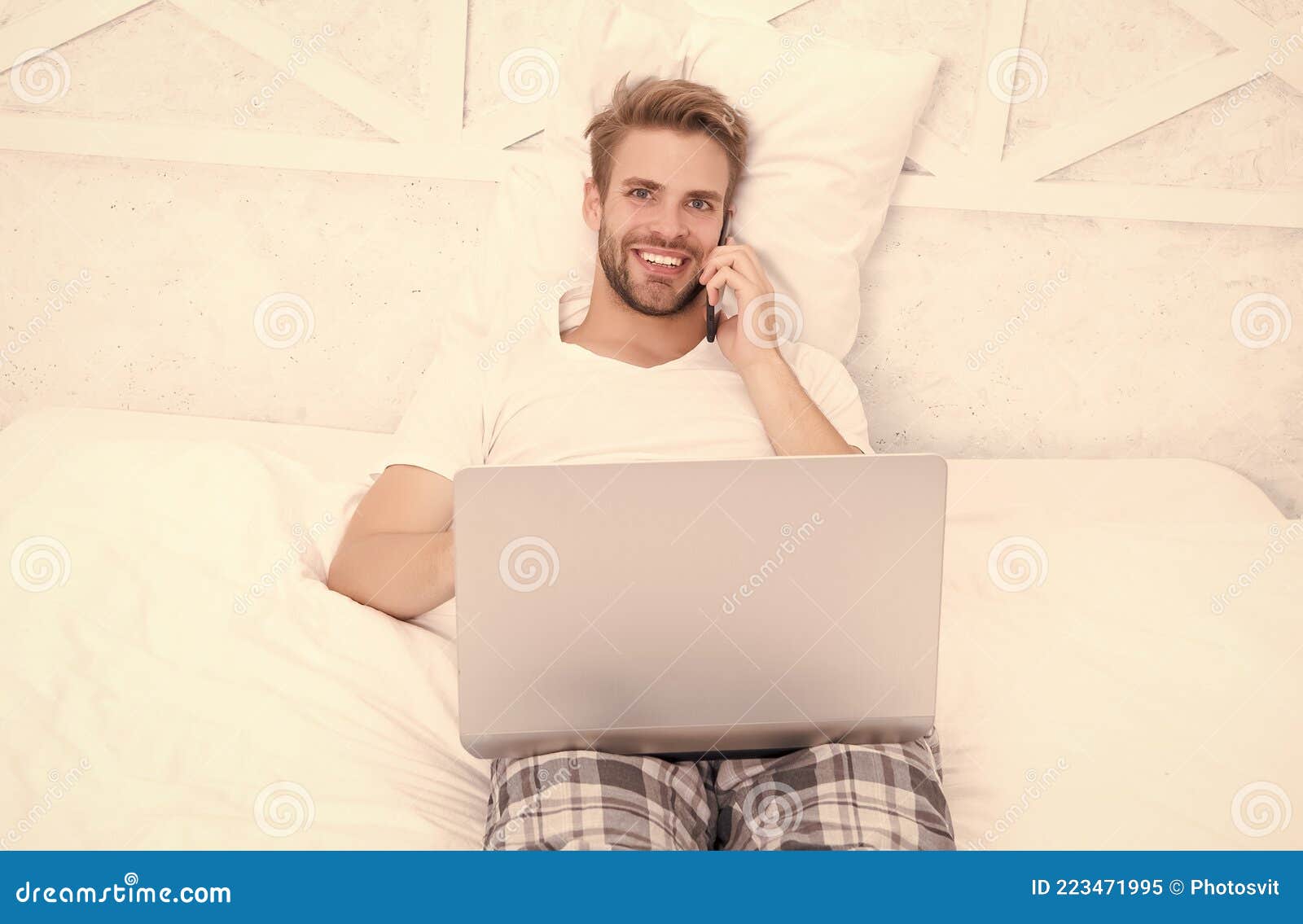 Happy Guy Talk on Phone Using Laptop Computer Technology in Bed ...