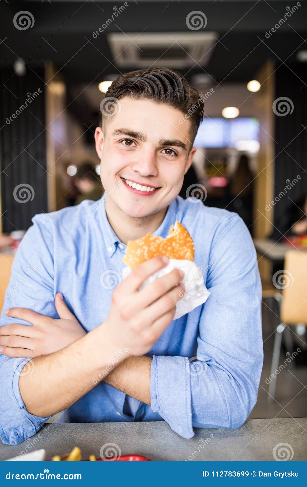 Happy Handsome Man Eating Burger in Cafe Stock Image - Image of butter ...
