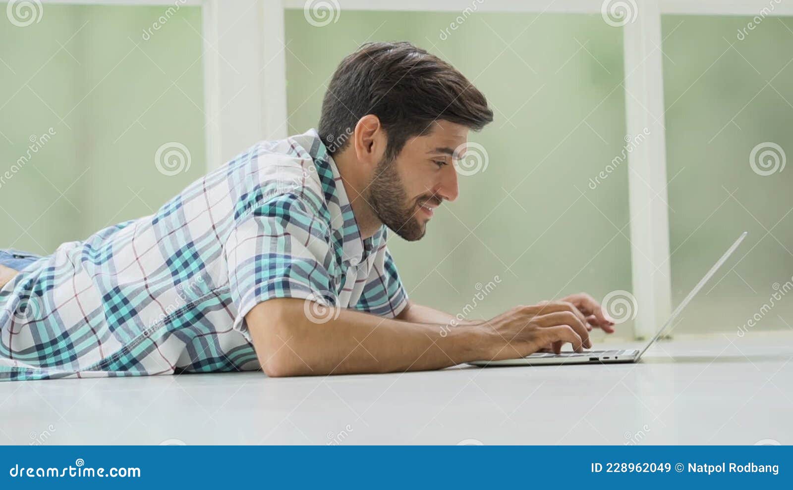 Happy Handsome Man Lying Down on Floor Using Laptop Computer at Home ...