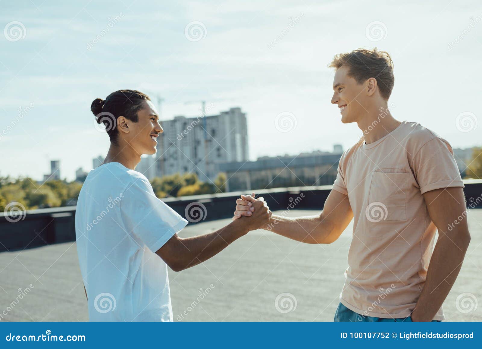 Friends shaking hands stock photo. Image of outdoors - 100107752