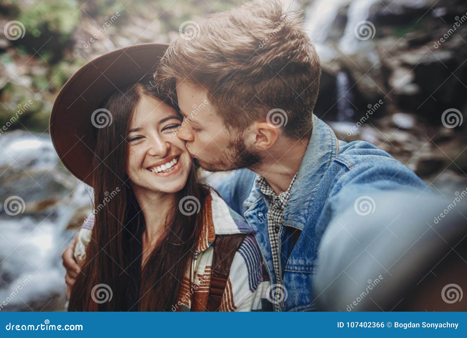 Happy Hipster Couple Taking Selfie At Waterfall In Forest Styli Stock