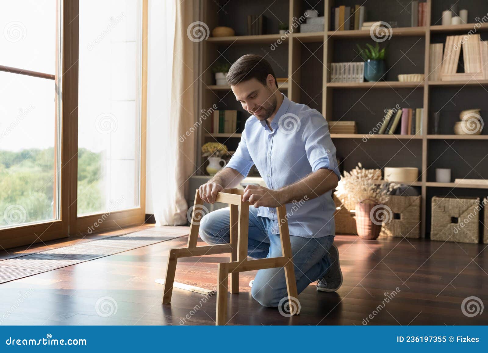 Happy Homeowner Man Assembling Wooden Furniture At New Home Stock Image