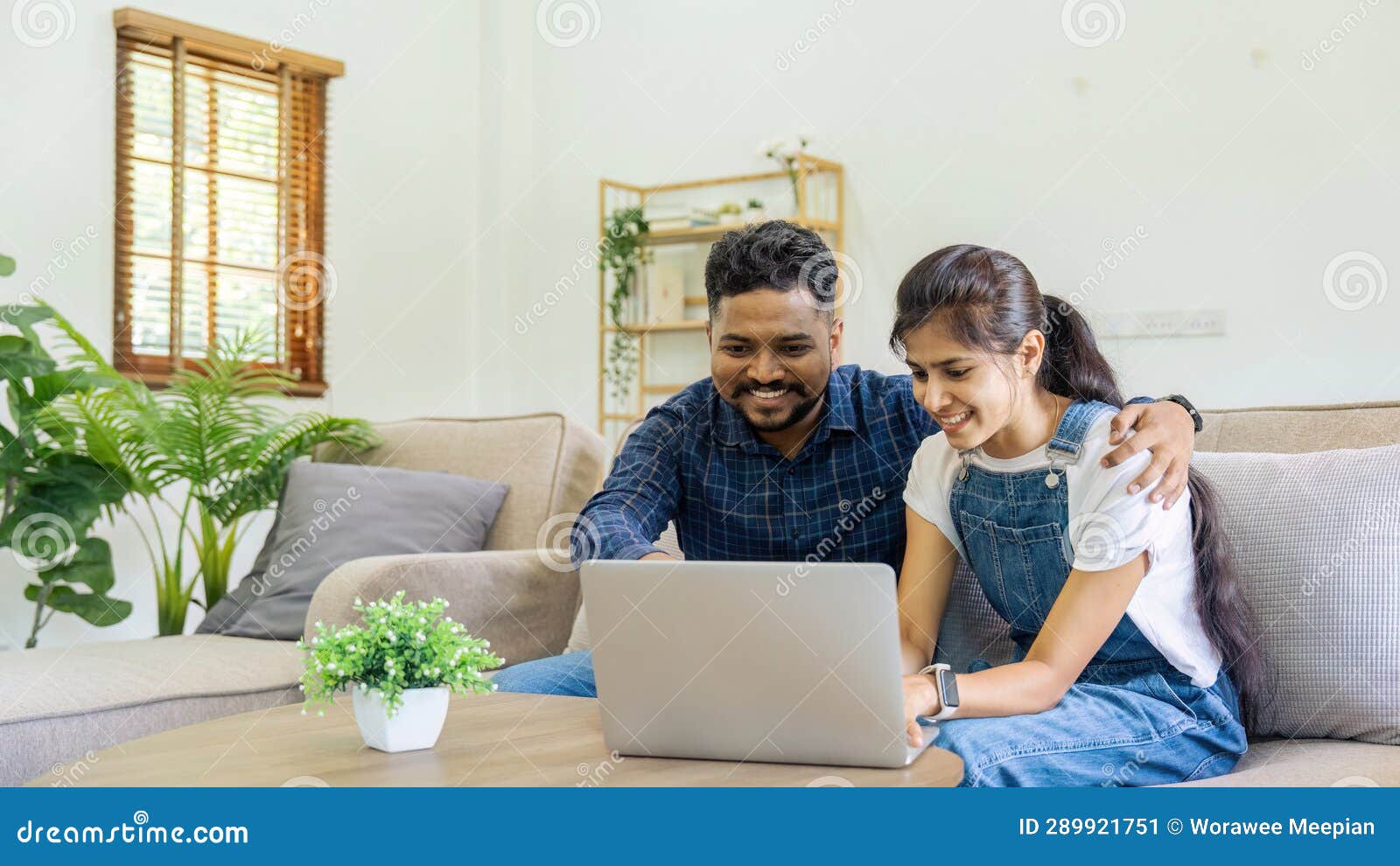 Happy Indian Couple Using Laptop Browsing Internet Together on Sofa at ...