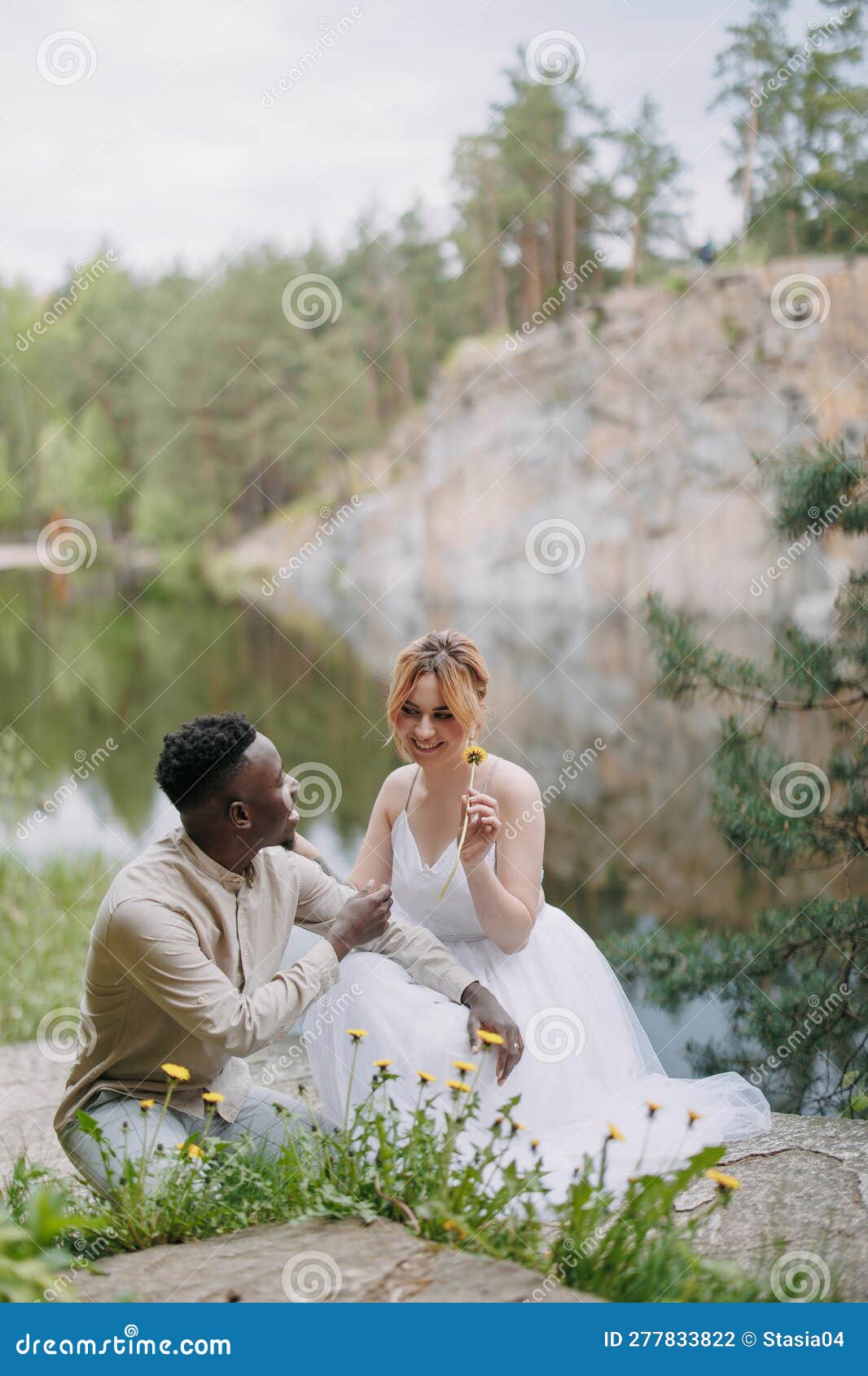 Happy Interracial Couple Newlyweds Sits And Has A Fun Near Dandelions