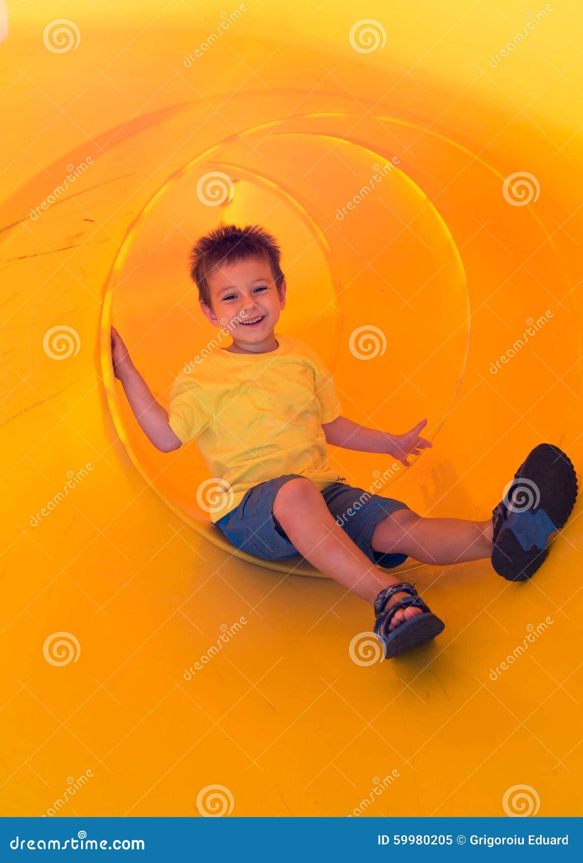 Happy kid in a tube slide stock image. Image of education - 59980205