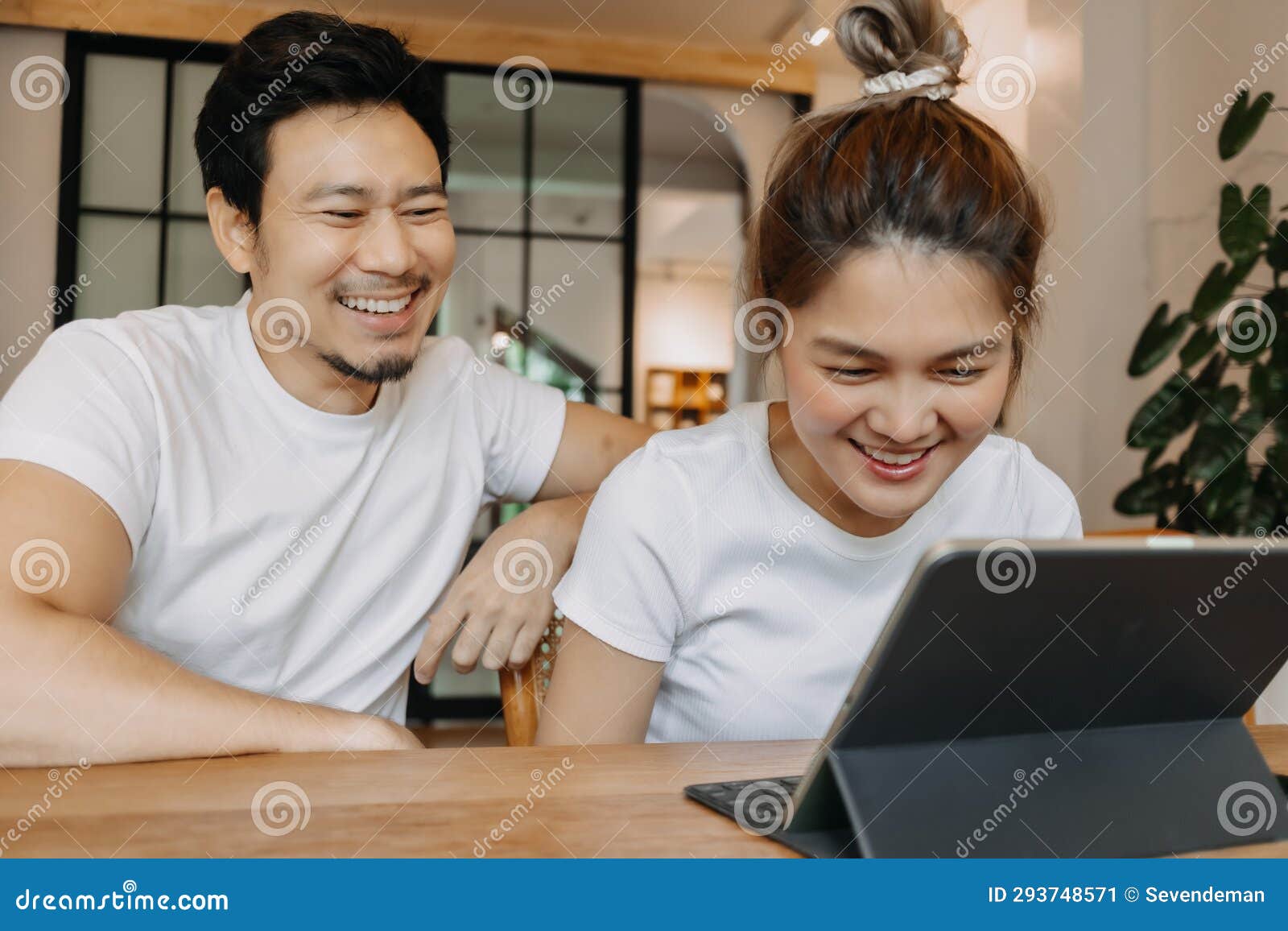 Happy Laughing Asian Couple Watching Computer Tablet Together in the ...