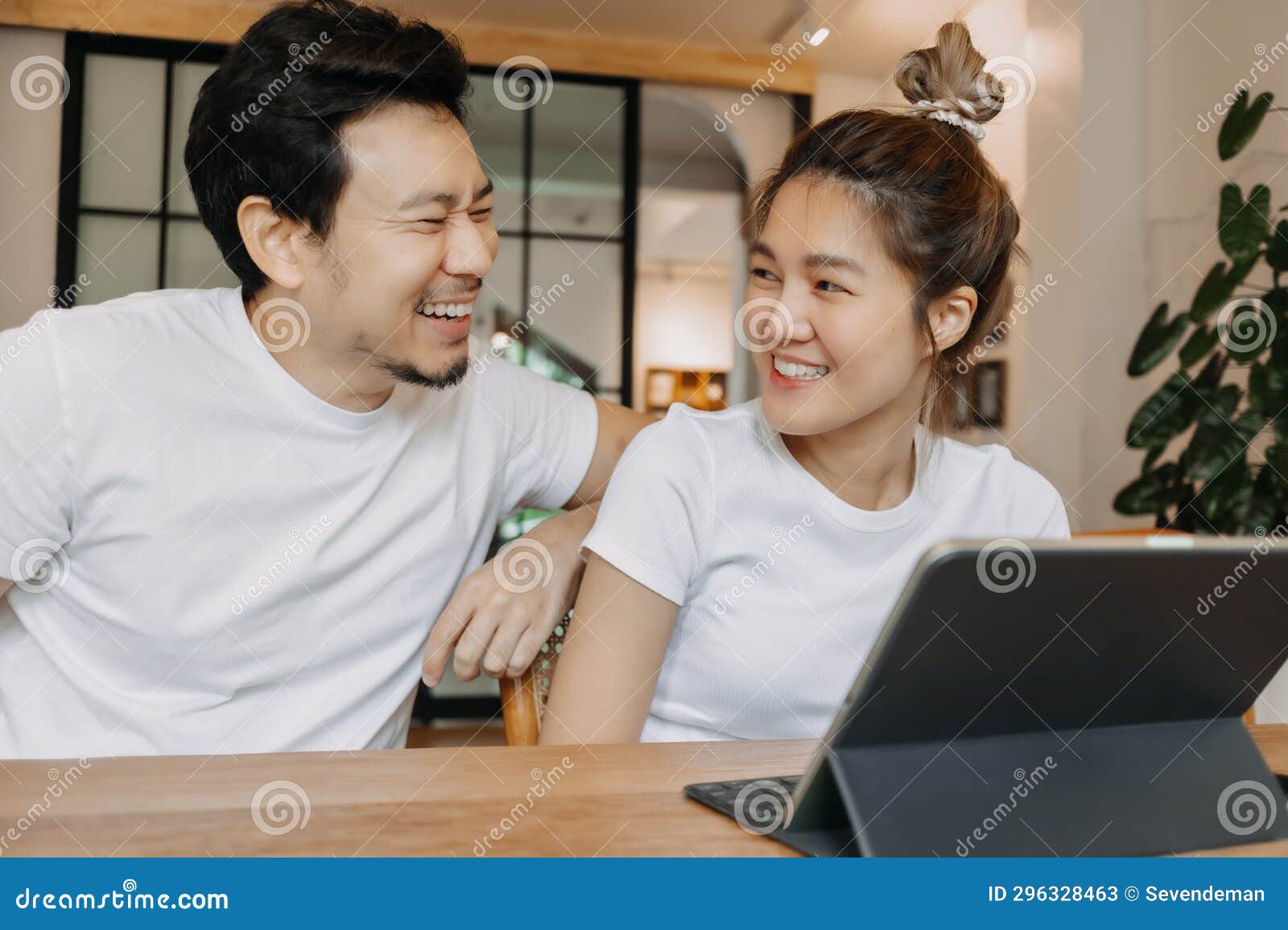 Happy Laughing Asian Couple Watching Computer Tablet Together in the ...