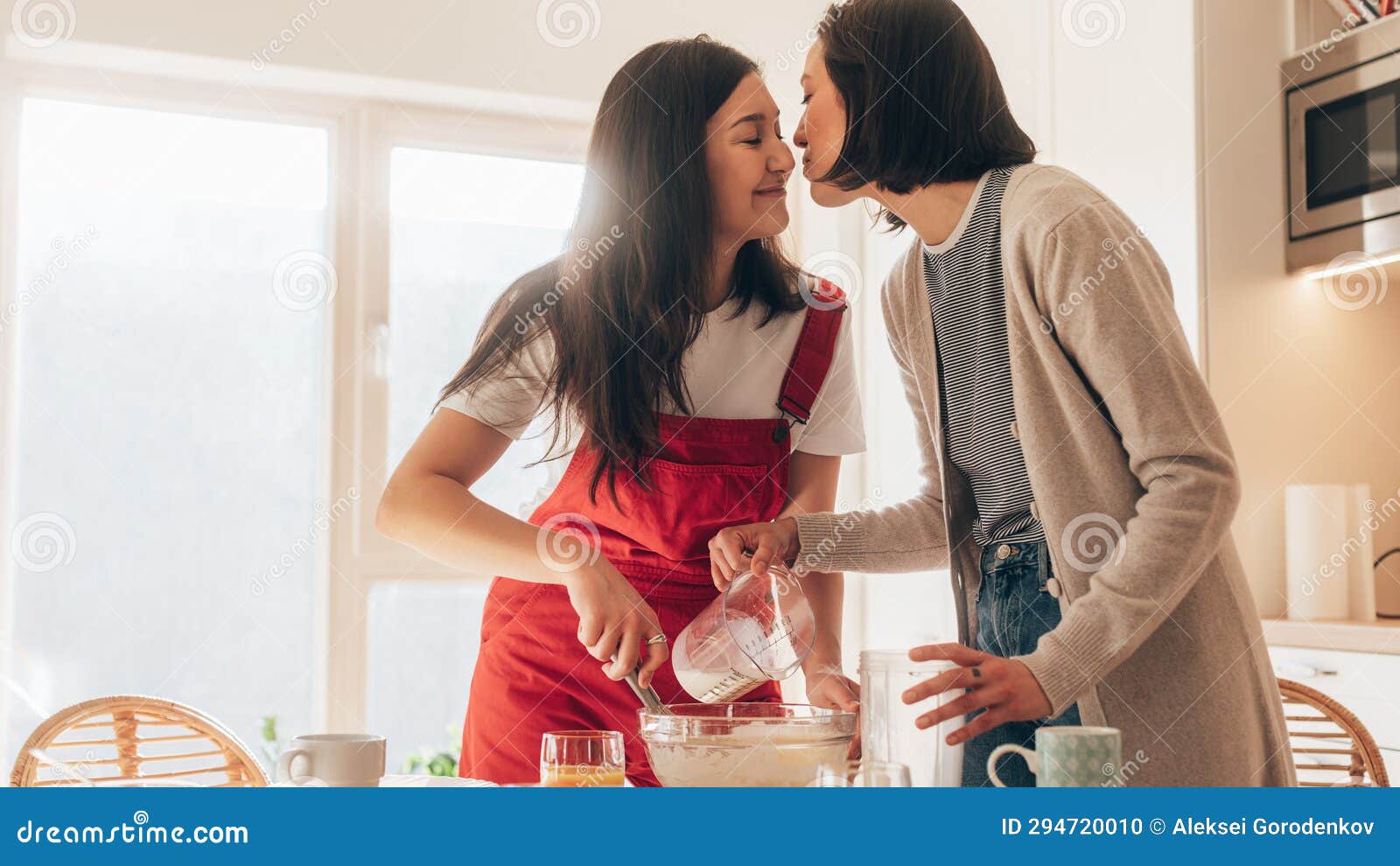 Happy Lesbian Couple Cooking Together In The Kitchen And Kiss Tenderly Lovely Two Girls In Love