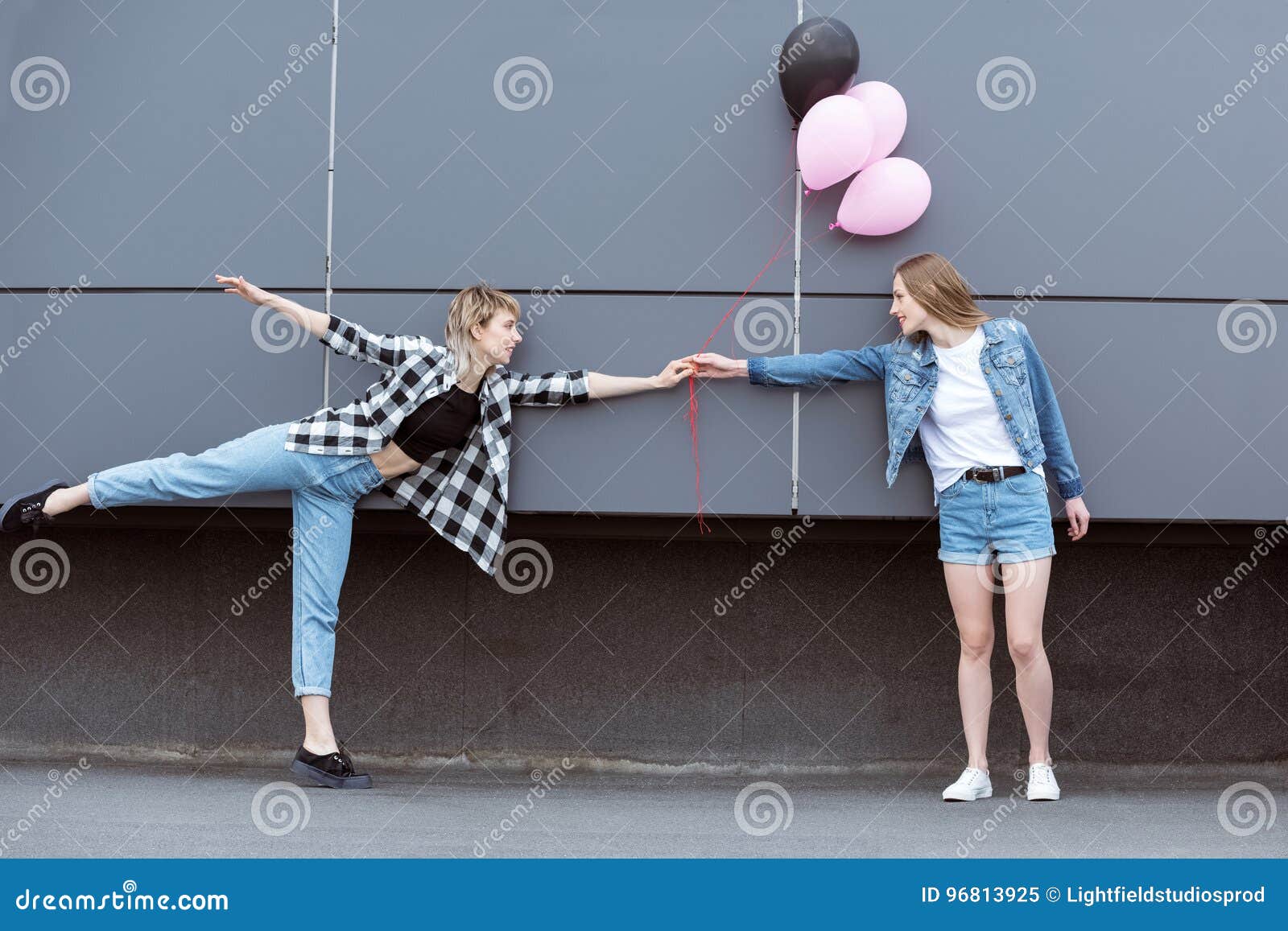 Happy Lesbian Couple Holding Hands With Air Balloons Outdoors Stock