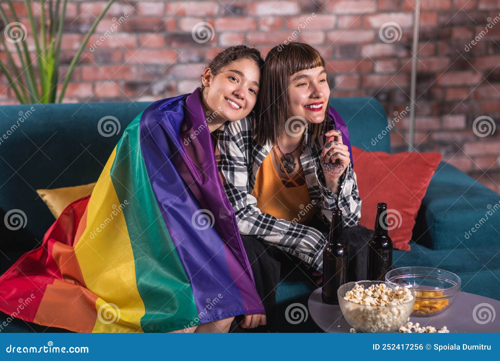 Happy Lesbian Couple Together Sitting On The Sofa In Living Room And