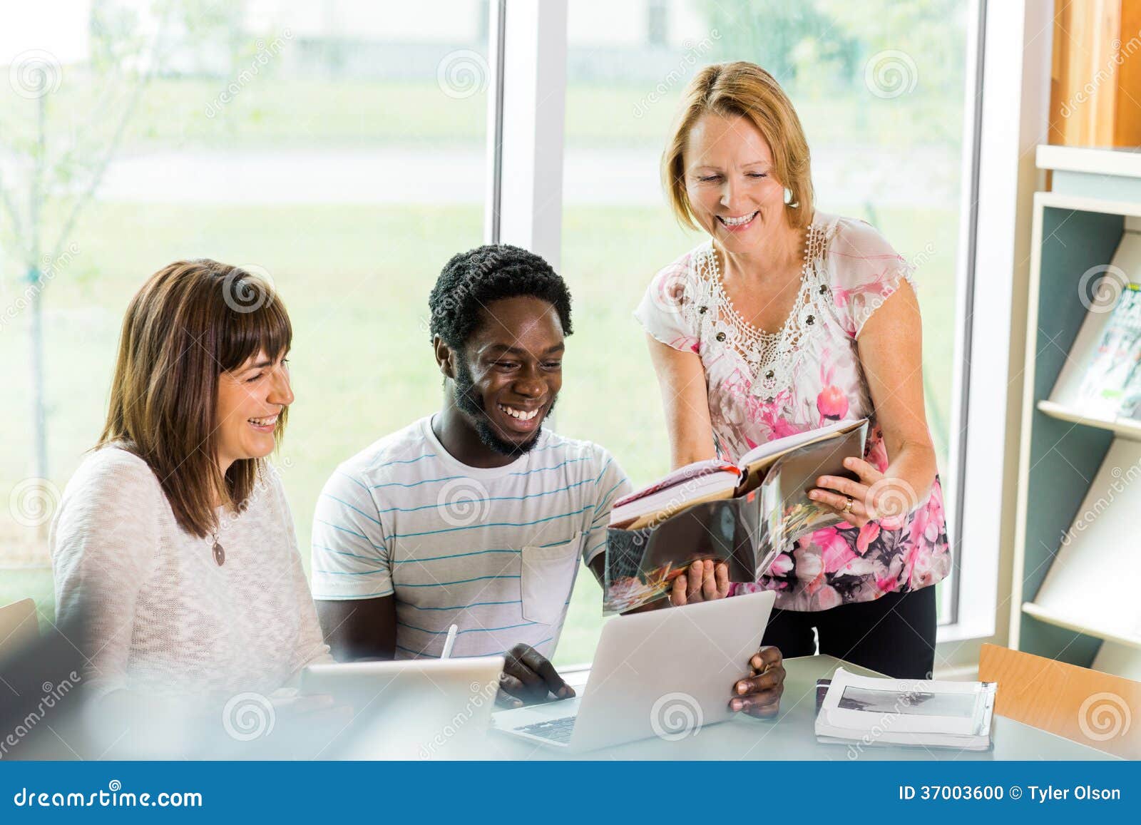Happy Librarian Assisting Students in Library Stock Photo - Image of ...