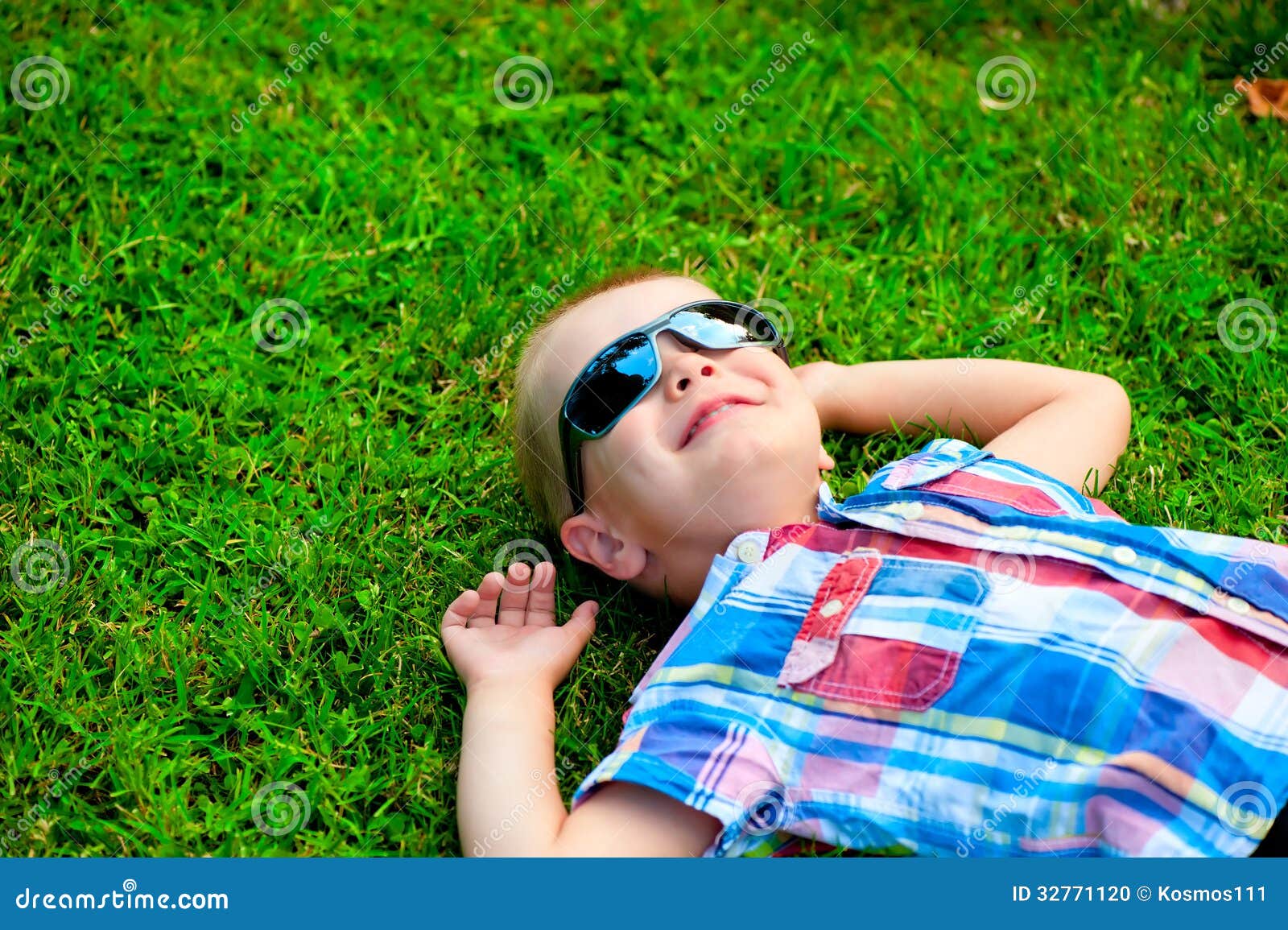 Happy Little Boy Lying Down Resting on the Green Grass Stock Photo ...