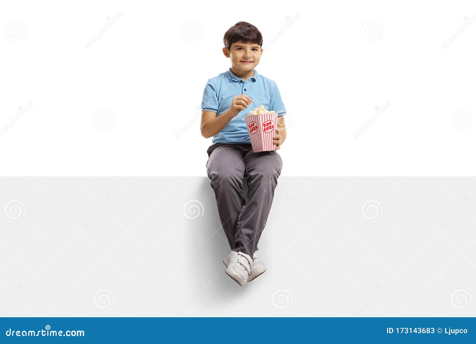 Happy Little Boy Sitting on a Panel and Eating Popcorn Stock Image ...