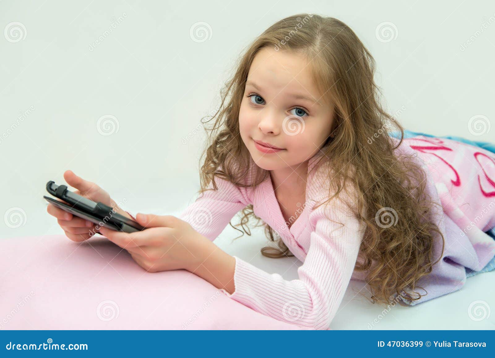 Happy Little Girl Lying on Bed with Tablet Computer Stock Image - Image ...