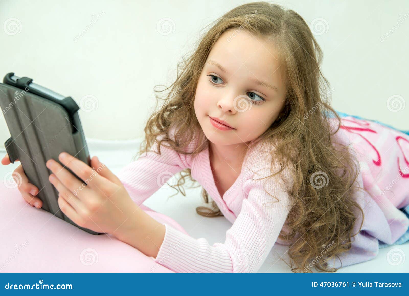 Happy Little Girl Lying on Bed with Tablet Computer Stock Image - Image ...