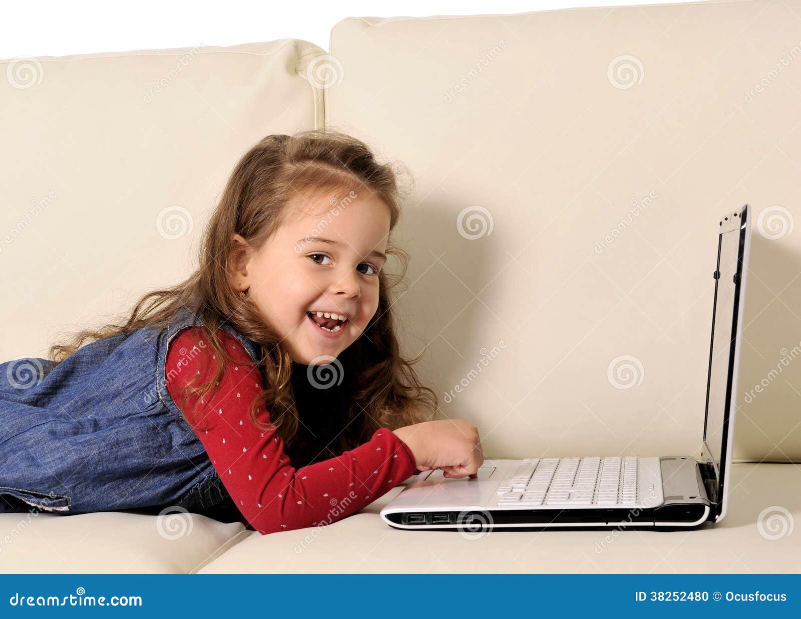 Happy Little Girl Lying on Couch Playing with Computer Stock Photo ...