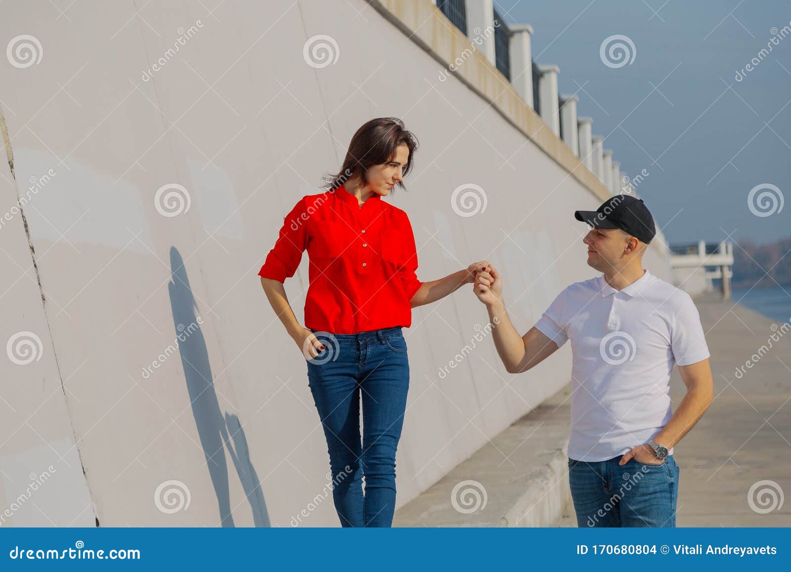 Happy Lovers Walk Along the Promenade Holding Hands. Stock Photo ...