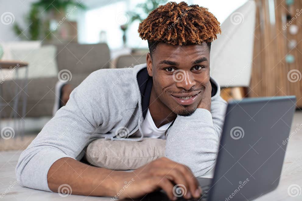 Happy Man Laying Down on Floor Using Laptop Stock Photo - Image of ...
